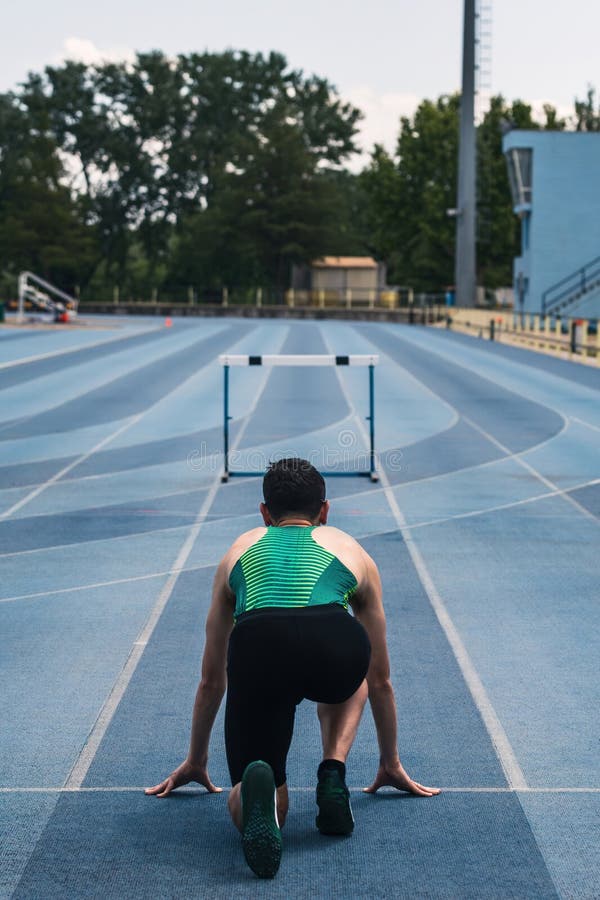 A Man is Crouching Down on a Track, Preparing To Run. Concept of ...