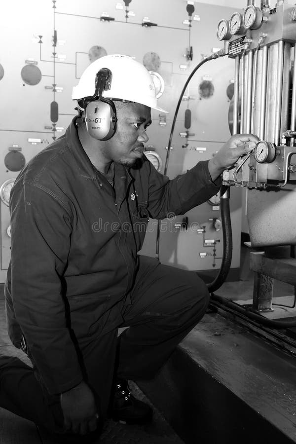A Man Kneeling Down and Working with a Machine on a Platform Editorial ...