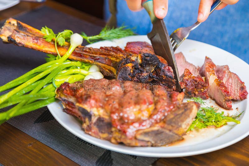 A Man Cuts Cooked Fried Meat in a Plate. Oven-roasted Meat for Dinner ...