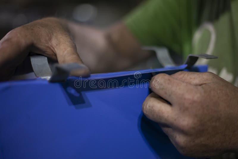 The Man Cuts the Excess Material with a Flat Knife. Stock Image - Image ...