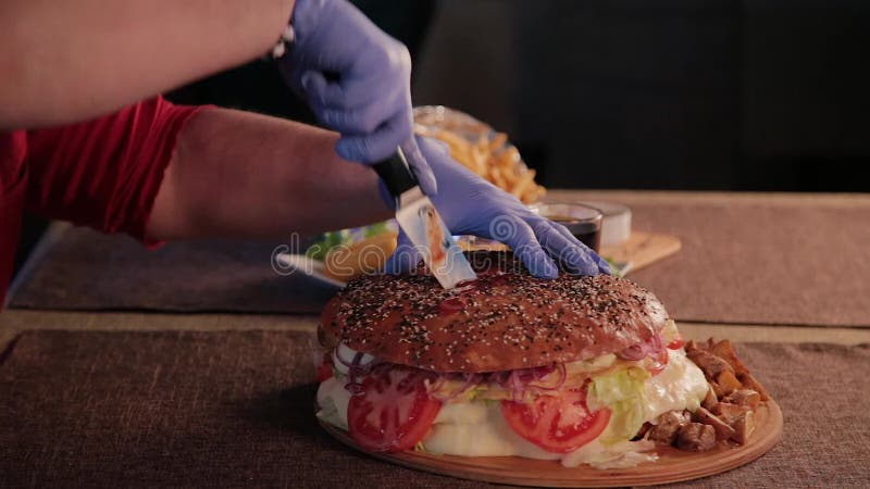 A Man Cuts a Huge Burger with a Knife. Stock Footage - Video of fast ...