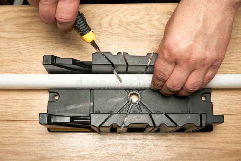 A Man Cuts a Polystyrene Baseboard with a Clerical Knife Using a Box To ...