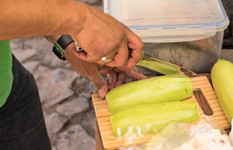 The man cuts the zucchini stock photo. Image of board - 94275646