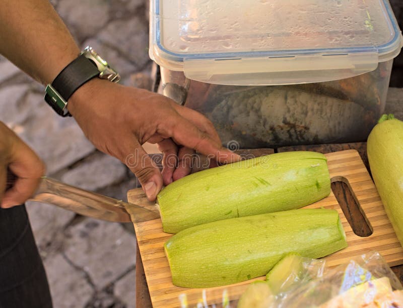 The man cuts the zucchini stock photo. Image of floor - 94275660