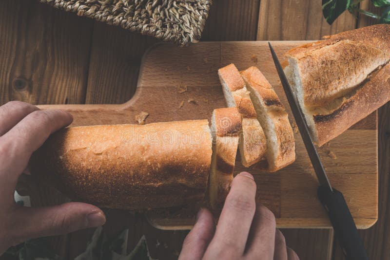 A Man Cutting Bread with a Tree Table Stock Photo - Image of home ...