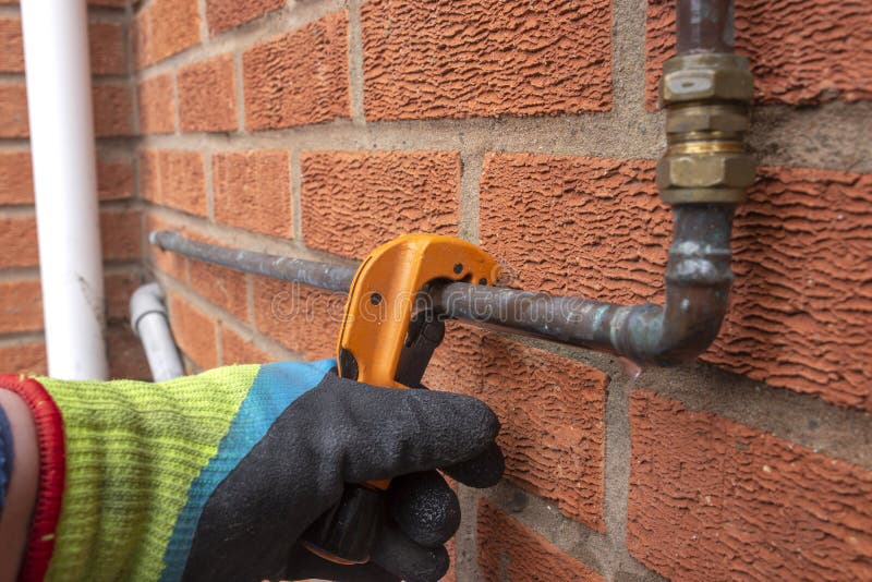 Man Cutting Copper Water Pipe with a Pipe Cutter Tool Outdoors. Stock ...