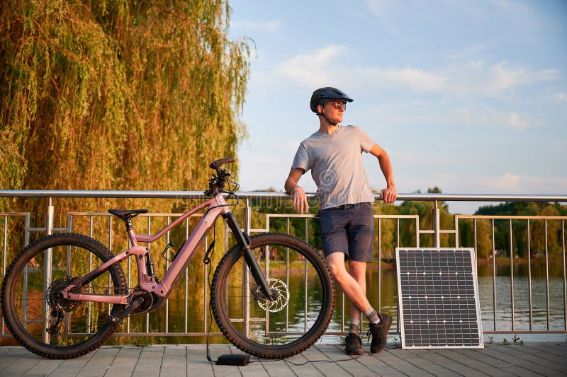 Man Cyclist Using Solar Panel for Charging Electric Mountain Bike ...