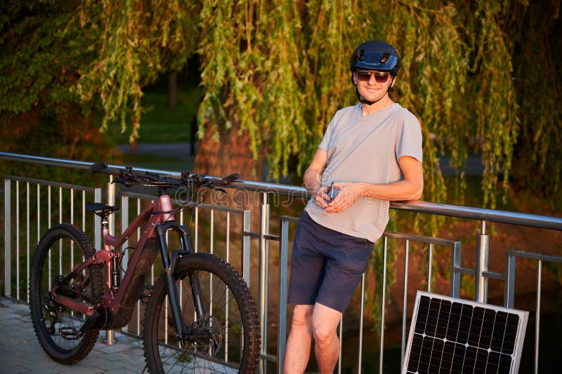 Man Cyclist Using Solar Panel for Charging Electric Mountain Bike ...
