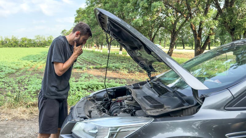 Man in Dark Clothes Examining Engine of Broken-down Car on Rural ...