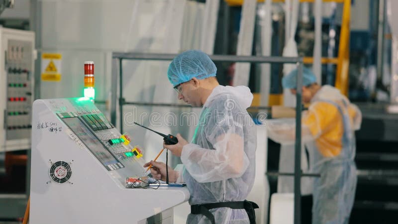 A Man at the Dashboard of a Machine in a Factory. a Worker at the ...