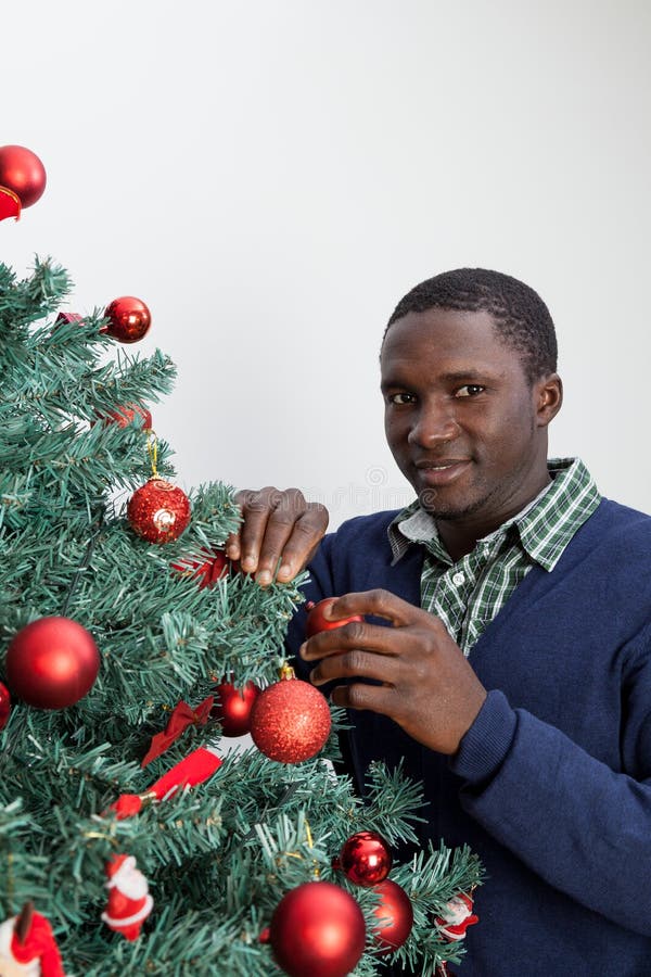 Man Decorating the Christmas Tree and Looking at Camera Stock Photo ...