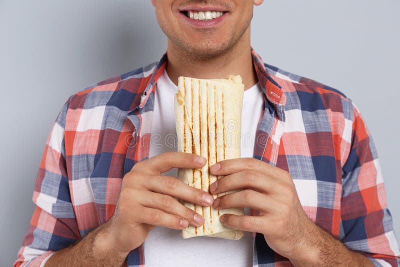 Man with Delicious Shawarma on Grey Background, Closeup Stock Photo ...
