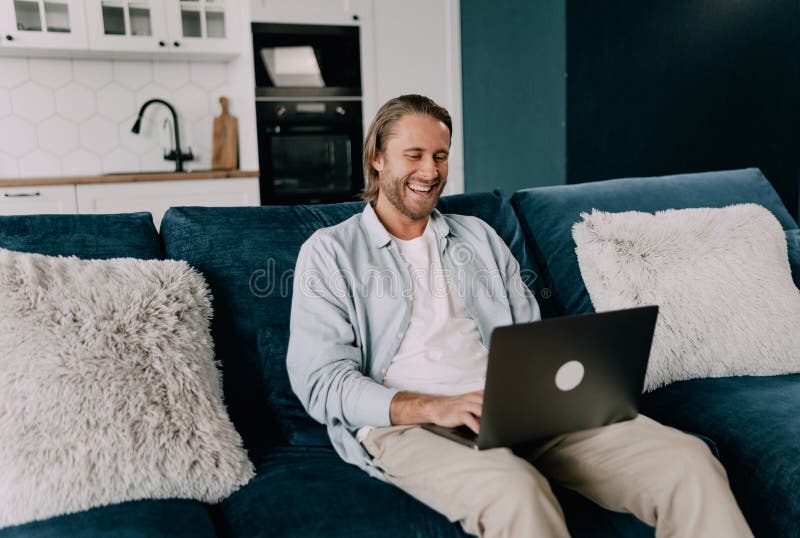A Man with a Delighted Smile Surfing the Net. Casually Dressed Relaxed ...