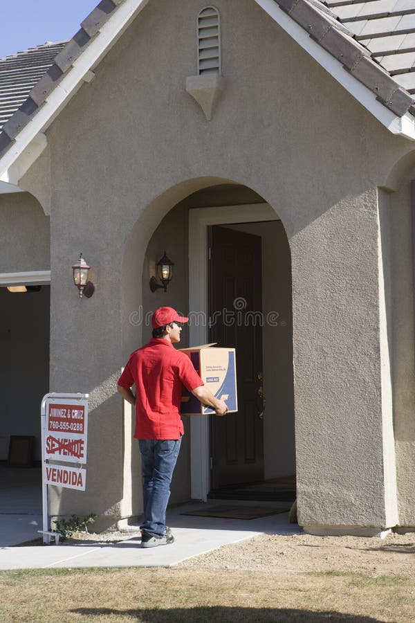 Man Delivering Cardboard Box into New House Stock Photo - Image of ...