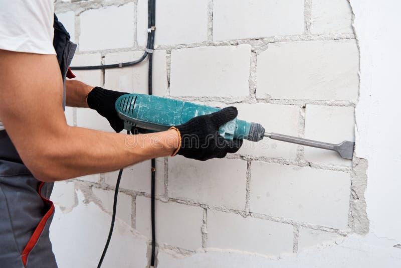 Man with Demolition Hammer Remove Stucco from Wall. Renovation Concept ...