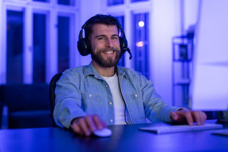 Smiling Man Using Computer at Night in Neon Light Stock Photo - Image ...