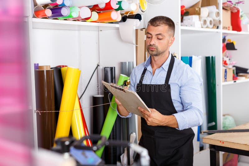 Man Designer and Print Operator with Vinyl Paper at Print Manufacturing ...