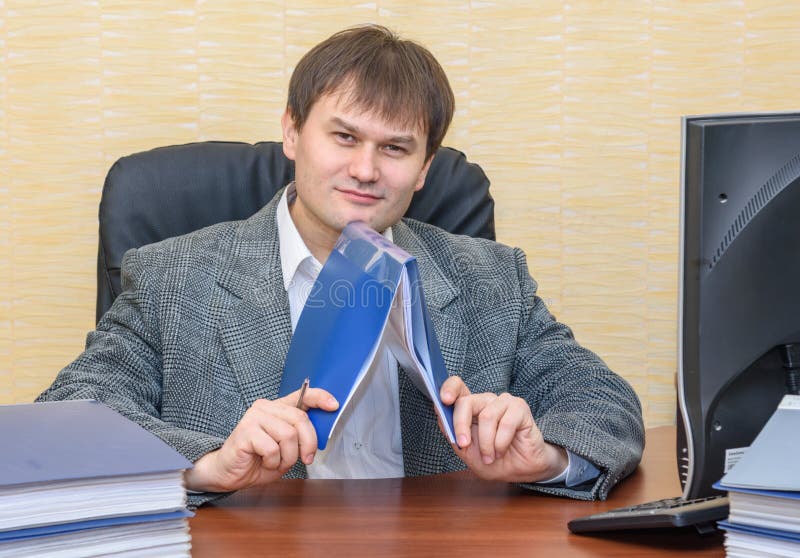 The Man at the Desk in the Office Holding a Folder with Documents Stock ...