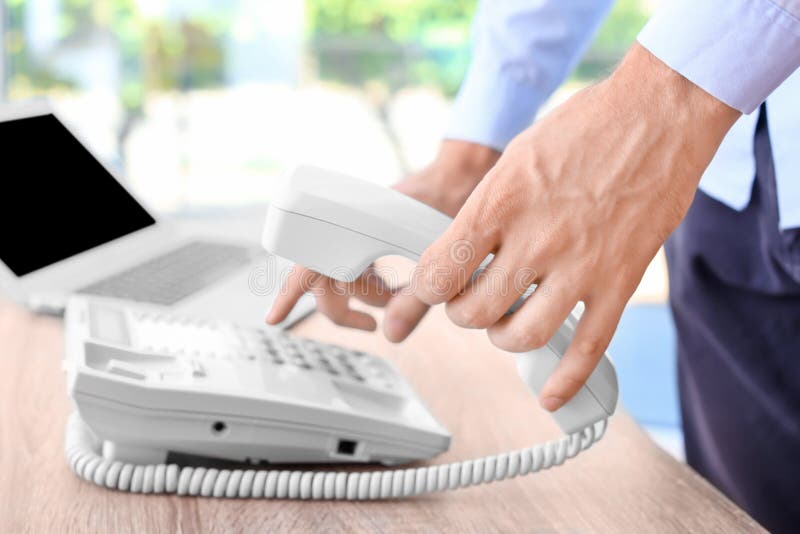 Young Man Dialing Number on Telephone at Workplace Stock Image - Image ...