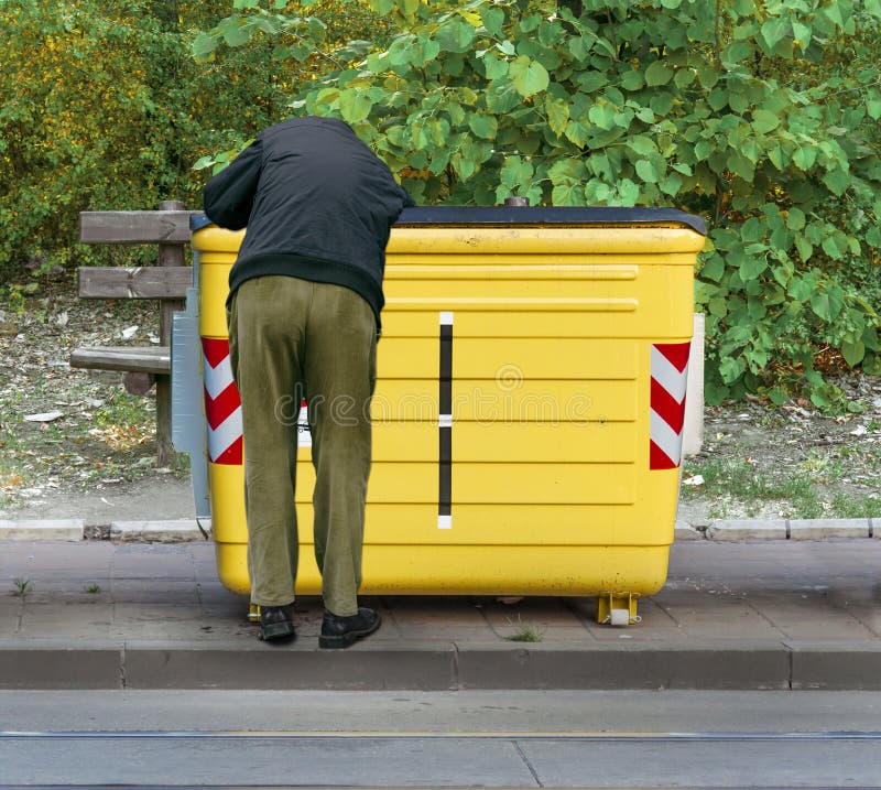 Man Digging through Garbage in Yellow Recycling Container Stock Photo ...