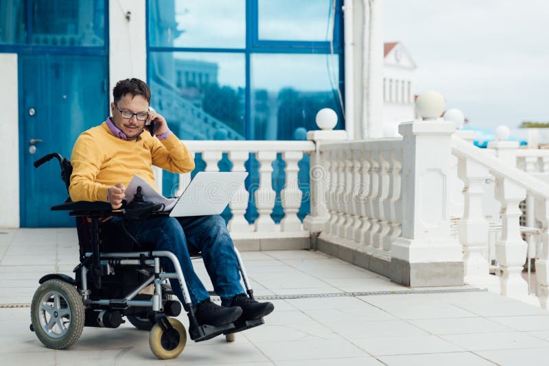 A Man with Disabilities in a Wheelchair Talking on a Smartphone Stock ...