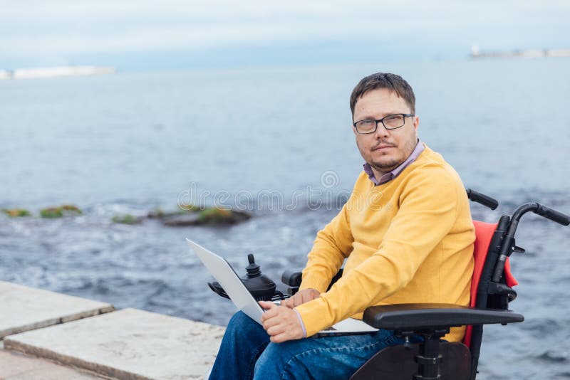 A Man with Disabilities in a Wheelchair Working with Documents Stock ...