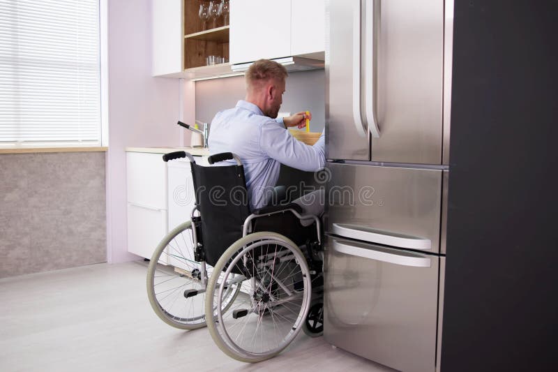 Man with Disability Sitting in Wheel Chair Preparing Food Stock Photo ...