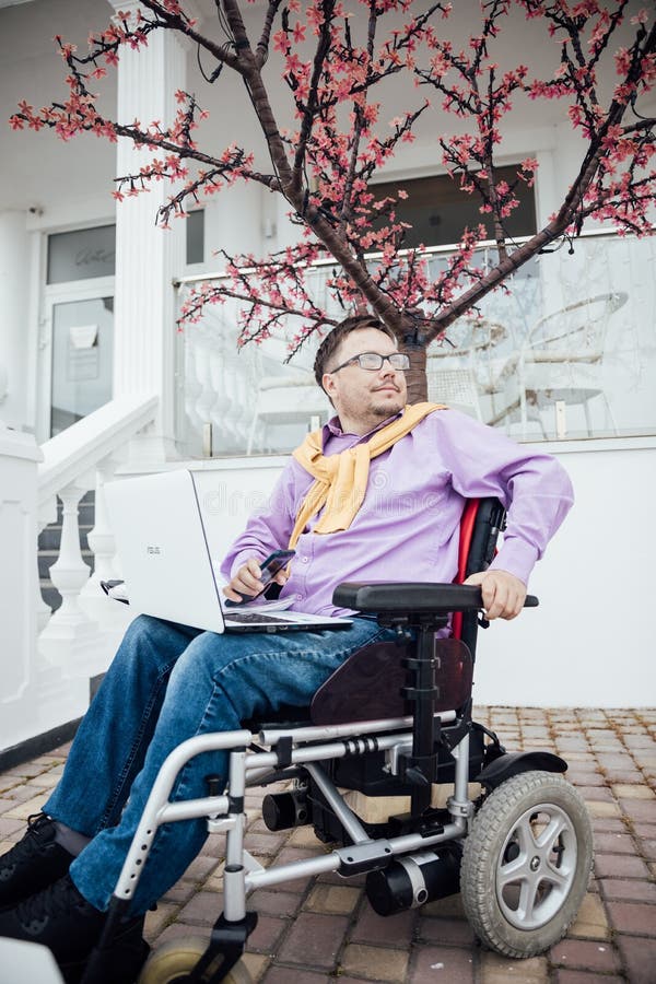 A Man with a Disability in a Wheelchair Looks at the View Stock Photo ...