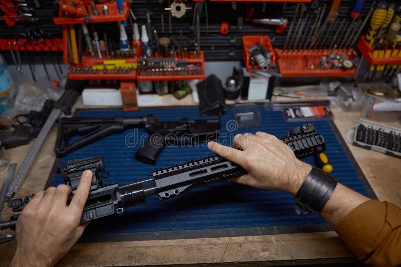 Man Disassembles and Cleans a Rifle in a Workshop Stock Photo - Image ...
