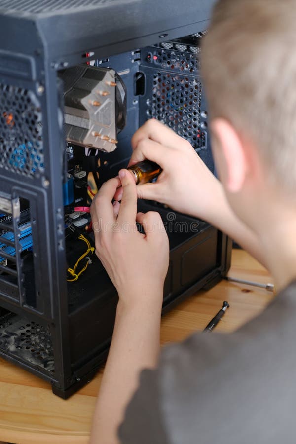 A Man Disassembles a Computer System Unit with a Screwdriver Stock ...
