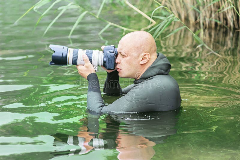 A Man in a Diving Suit in the Water with Slr Camera Stock Image - Image ...