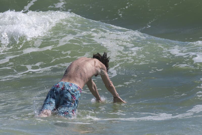 Man Diving into the Surf editorial stock photo. Image of coast - 275000778