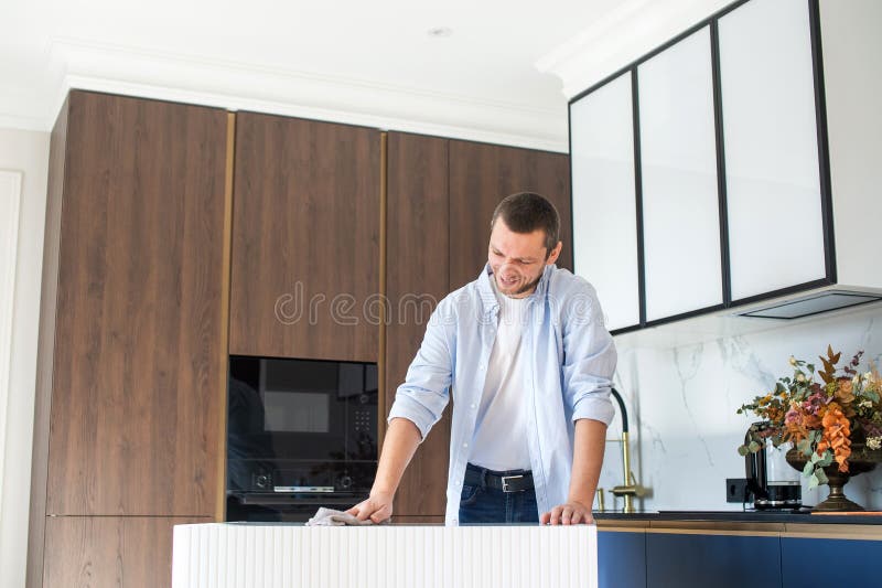A Man Does Wet Cleaning in the Kitchen, Wiping the Table with a Napkin ...