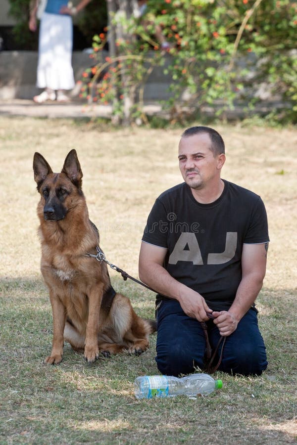 German Shepherd and His Master Sitting on Grass Editorial Image - Image ...