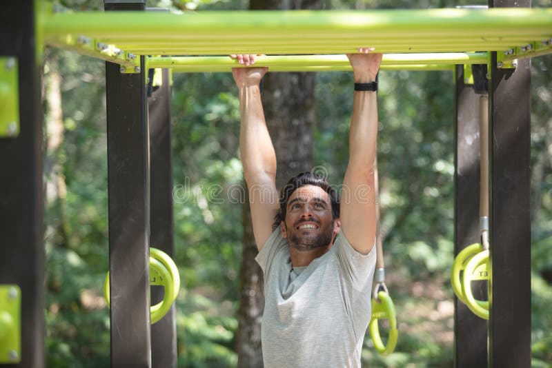 Man Doing Abdominal Exercise on Horizontal Bar in Summer Park Stock ...