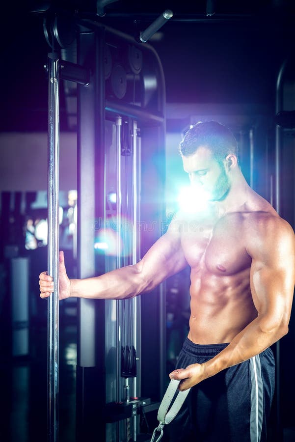 Man doing cable fly in gym stock image. Image of posing - 53306421