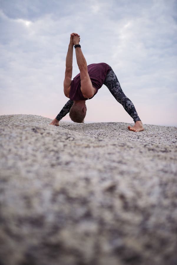Man Doing the Clasp Hands Forward Fold Pose at Dusk Stock Photo - Image ...