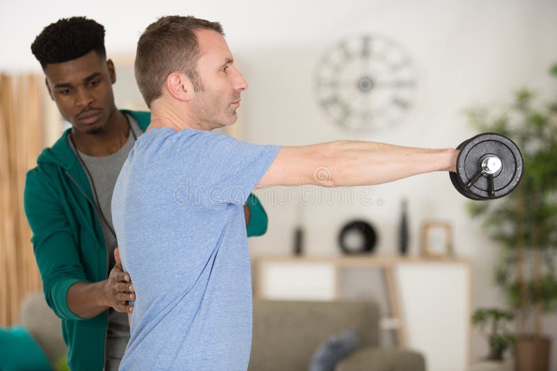 Man Doing Exercise with Dumbbells with Personal Trainer Stock Photo ...