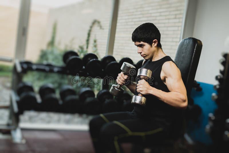 Man doing exercise in gym stock photo. Image of athletic - 70353352