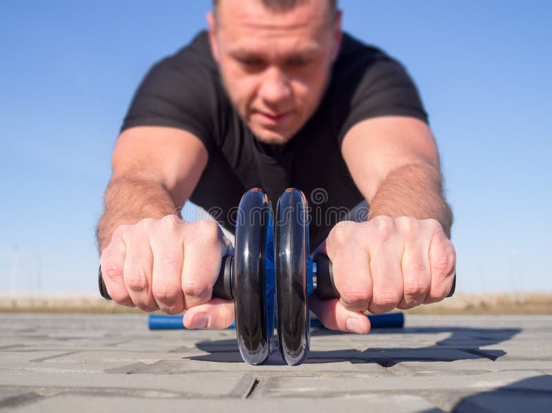Man Doing Exercises with a Power Wheel Outdoor. Stock Image - Image of ...