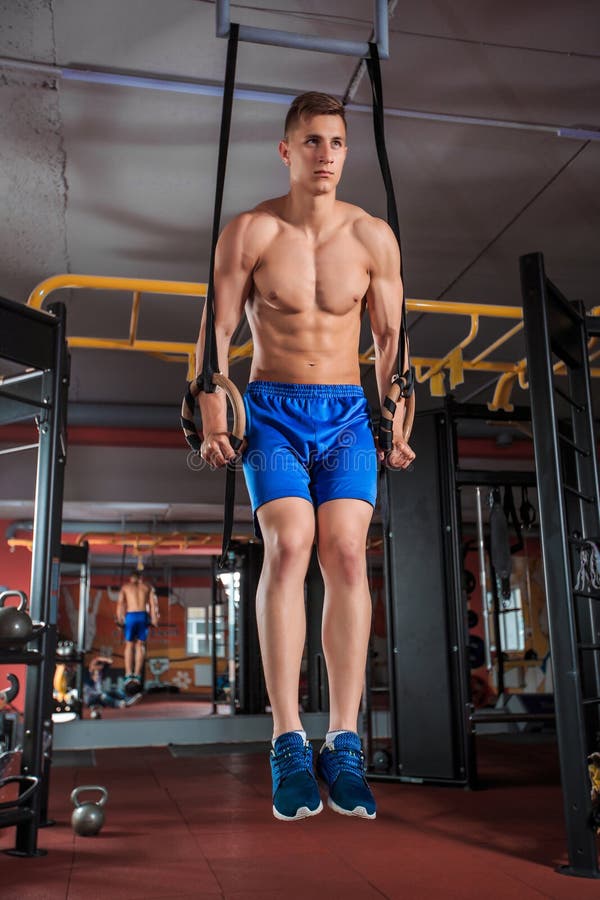 Man Doing Exercises on the Rings in the Gym Stock Photo - Image of ...