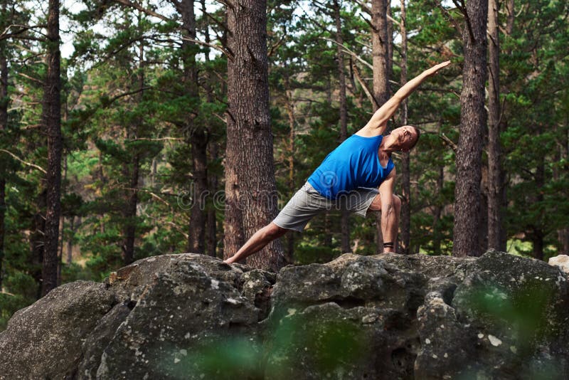 Man Doing the Extending Side Angle Pose in a Forest Stock Image - Image ...
