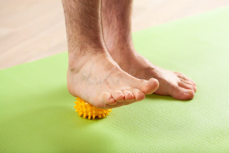 Man Doing Flatfoot Correction Gymnastic Exercise Using Massage Ball at ...