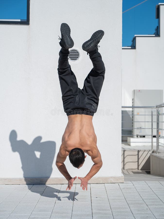Man Doing a Handstand Outdoors Against a White Wall. Stock Image ...