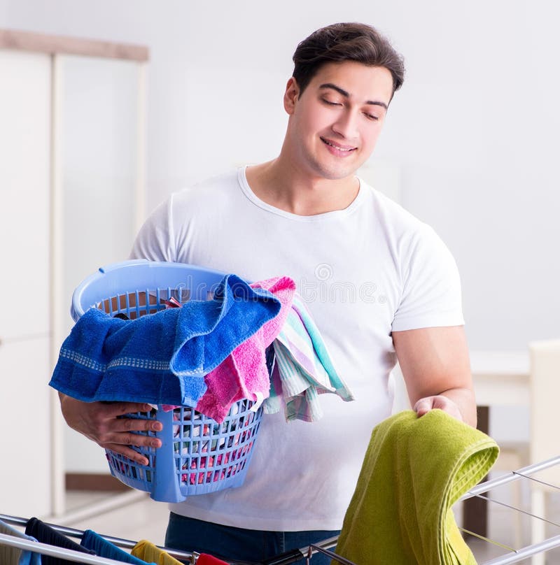 Man doing laundry at home stock photo. Image of folding - 241277738