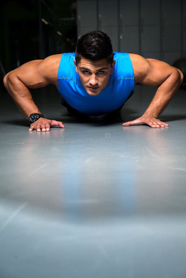 Man Doing Press Ups in Gym stock photo. Image of muscular - 32780206