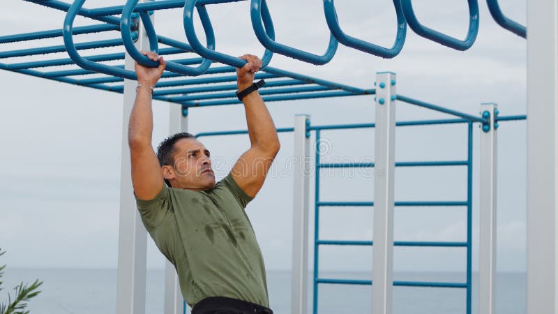 Man Doing Pull Ups Across Monkey Bar Stock Image - Image of fitness ...