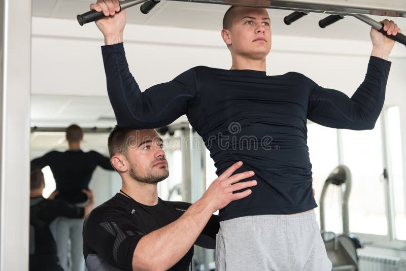 Man Doing Pull-Ups Exercises with Gym Coach Stock Photo - Image of ...