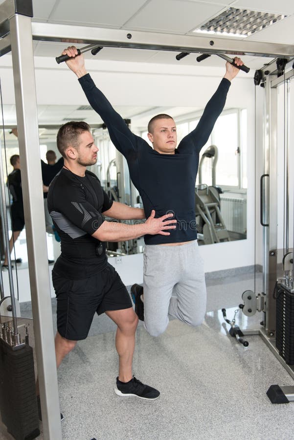 Man Doing Pull-Ups Exercises with Gym Coach Stock Image - Image of ...