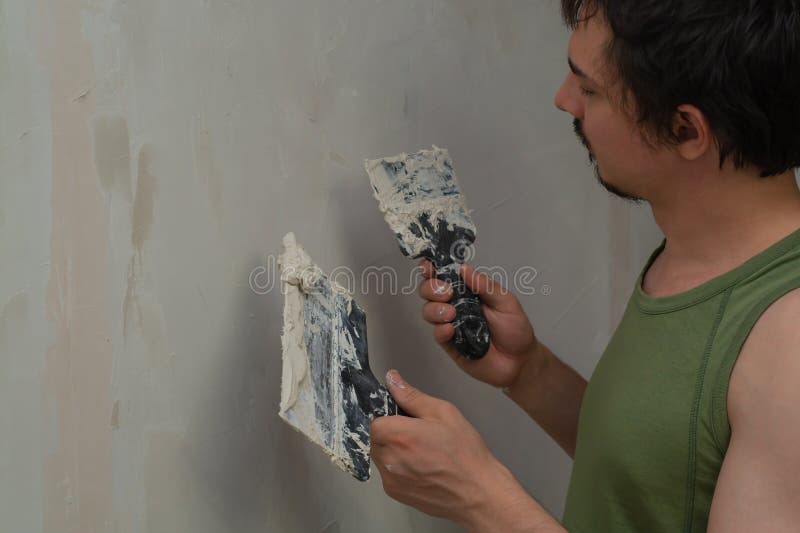 Man Doing Repairs. Worker Applies with Putty To the Wall. Working ...